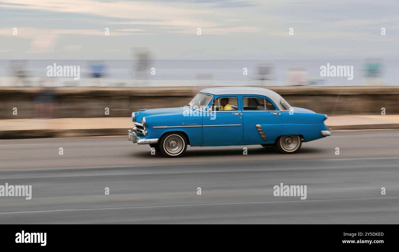 738 Old white-roofed blue American classic car -Ford from 1952- driving ...