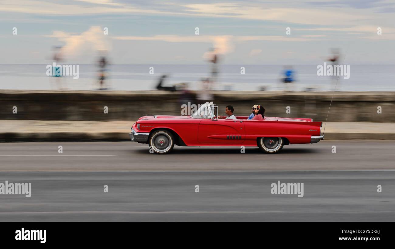 740 Old crimson red American classic car -Ford from 1959- driving on ...
