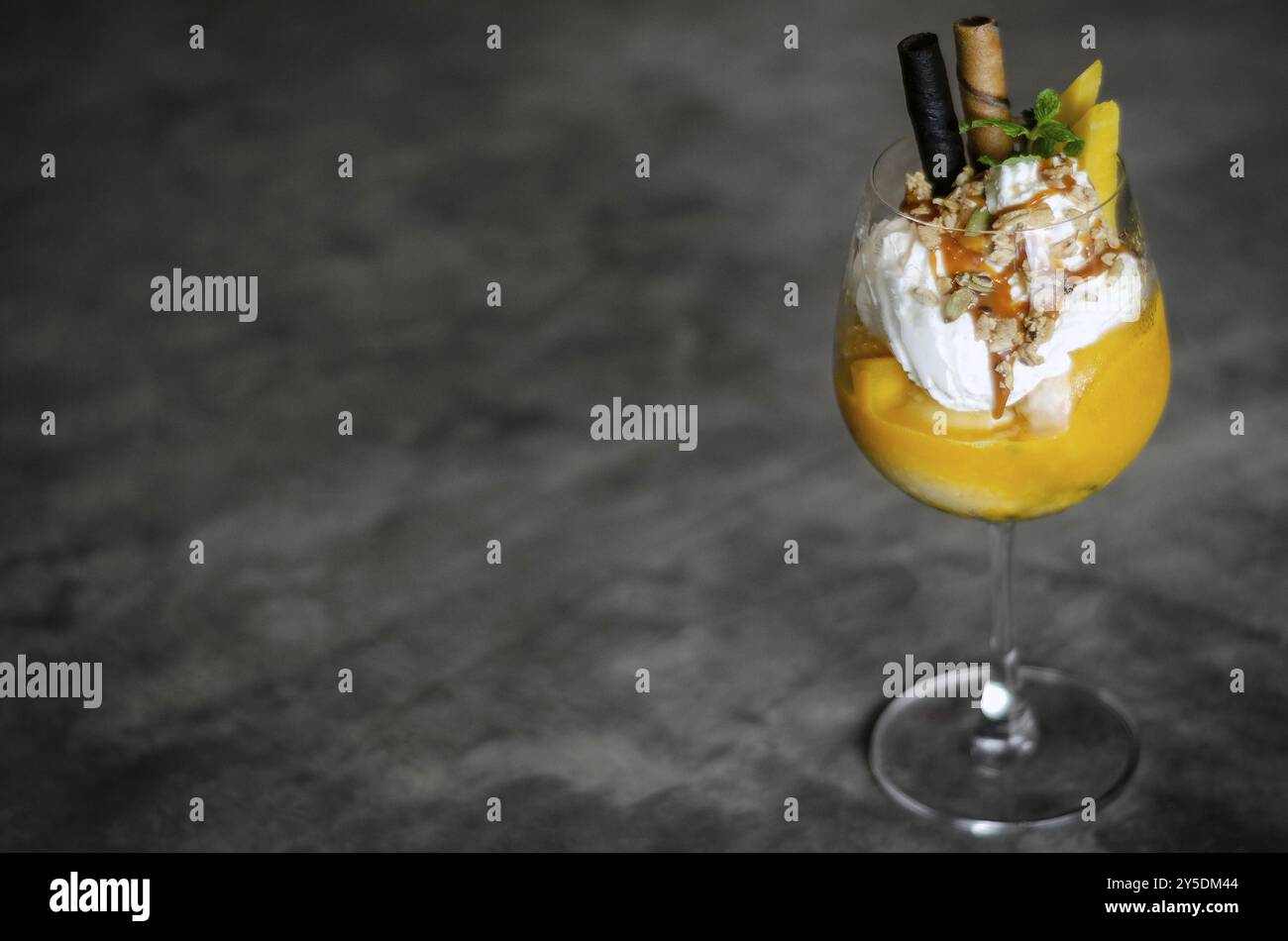 Organic mango and passion fruit tropical ice cream sundae in wine glass ...