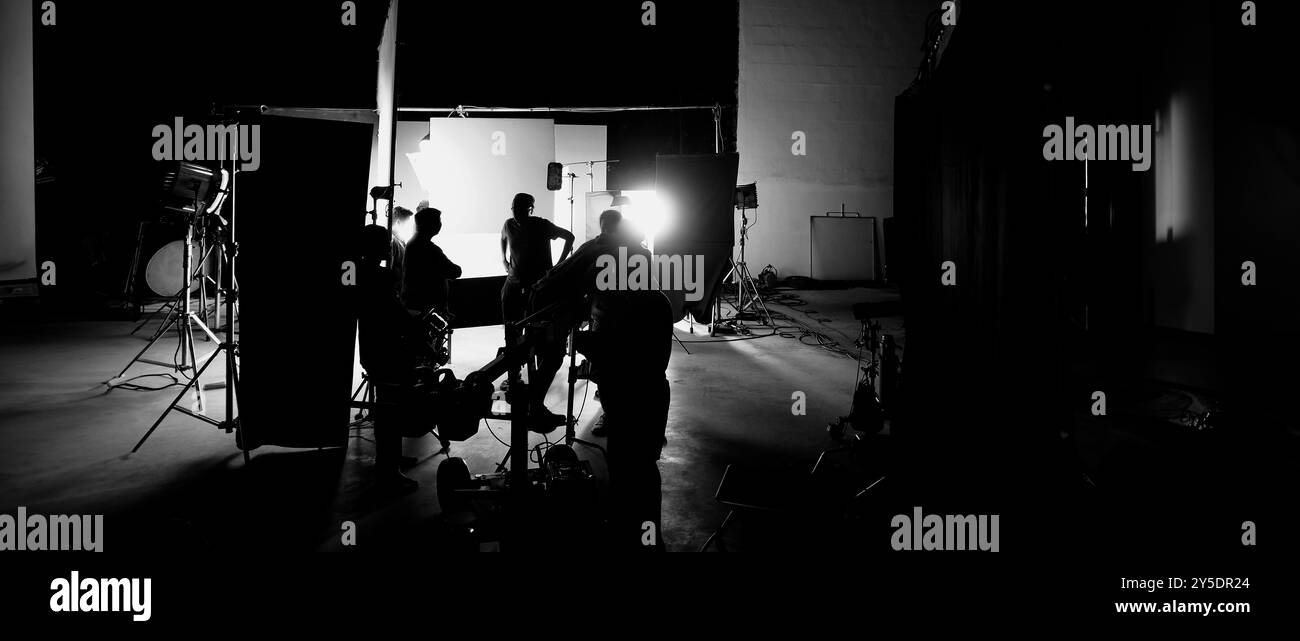 Silhouette of film crews and video camera on special dolly crane with ...