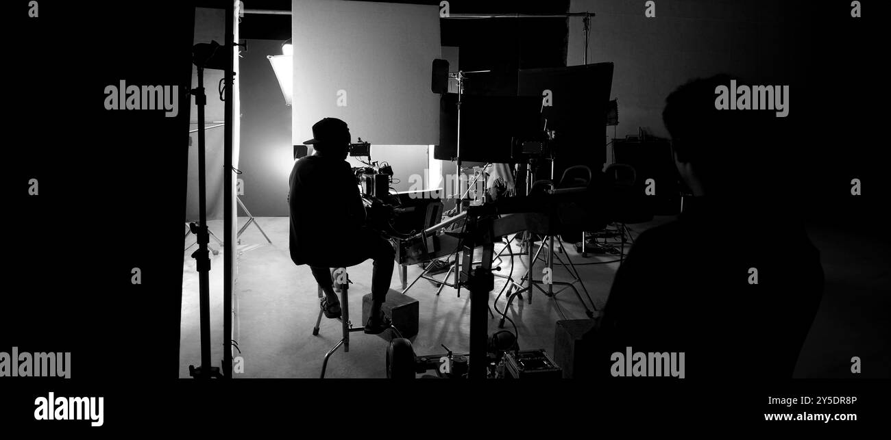 Silhouette of film crews and video camera on special dolly crane with ...
