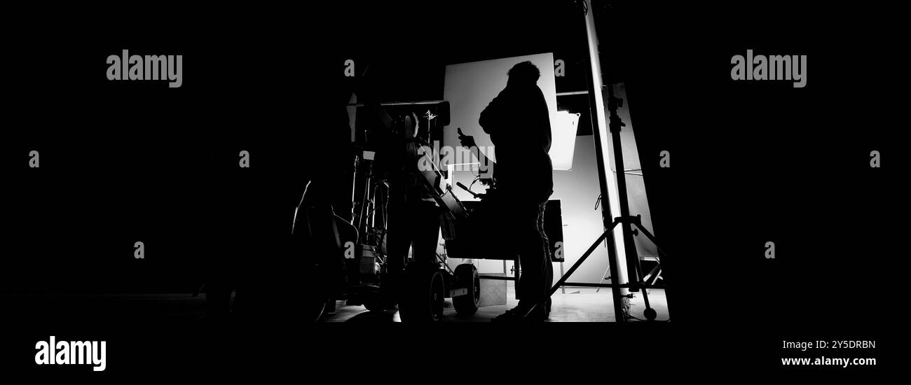 Silhouette of film crews and video camera on special dolly crane with ...