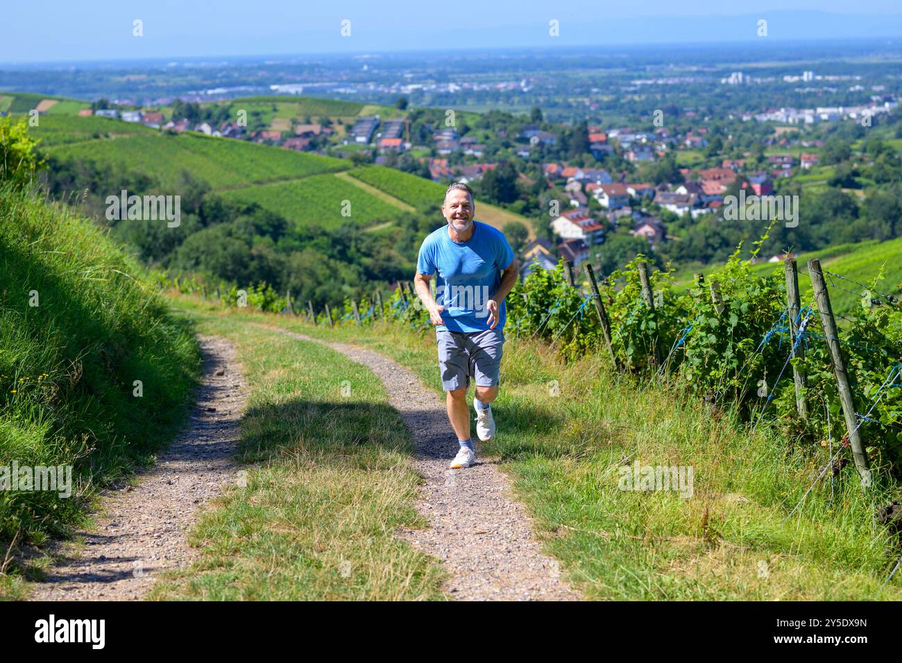 A man pushes forward on an uphill trail, jogging through the vibrant ...