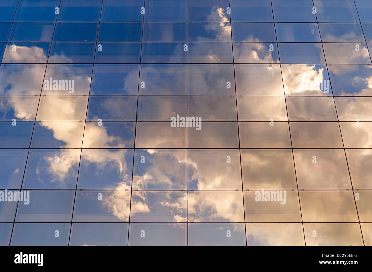 Architectural detail, clouds reflected in the glass wall of a modern ...