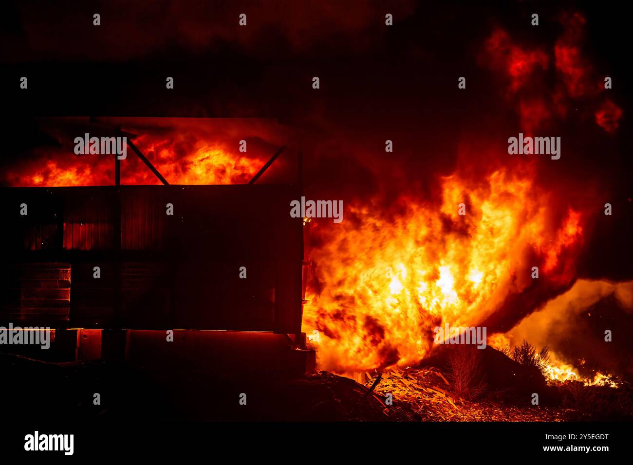 Exploding warehouse. Burning industrial building. Big blaze at night ...