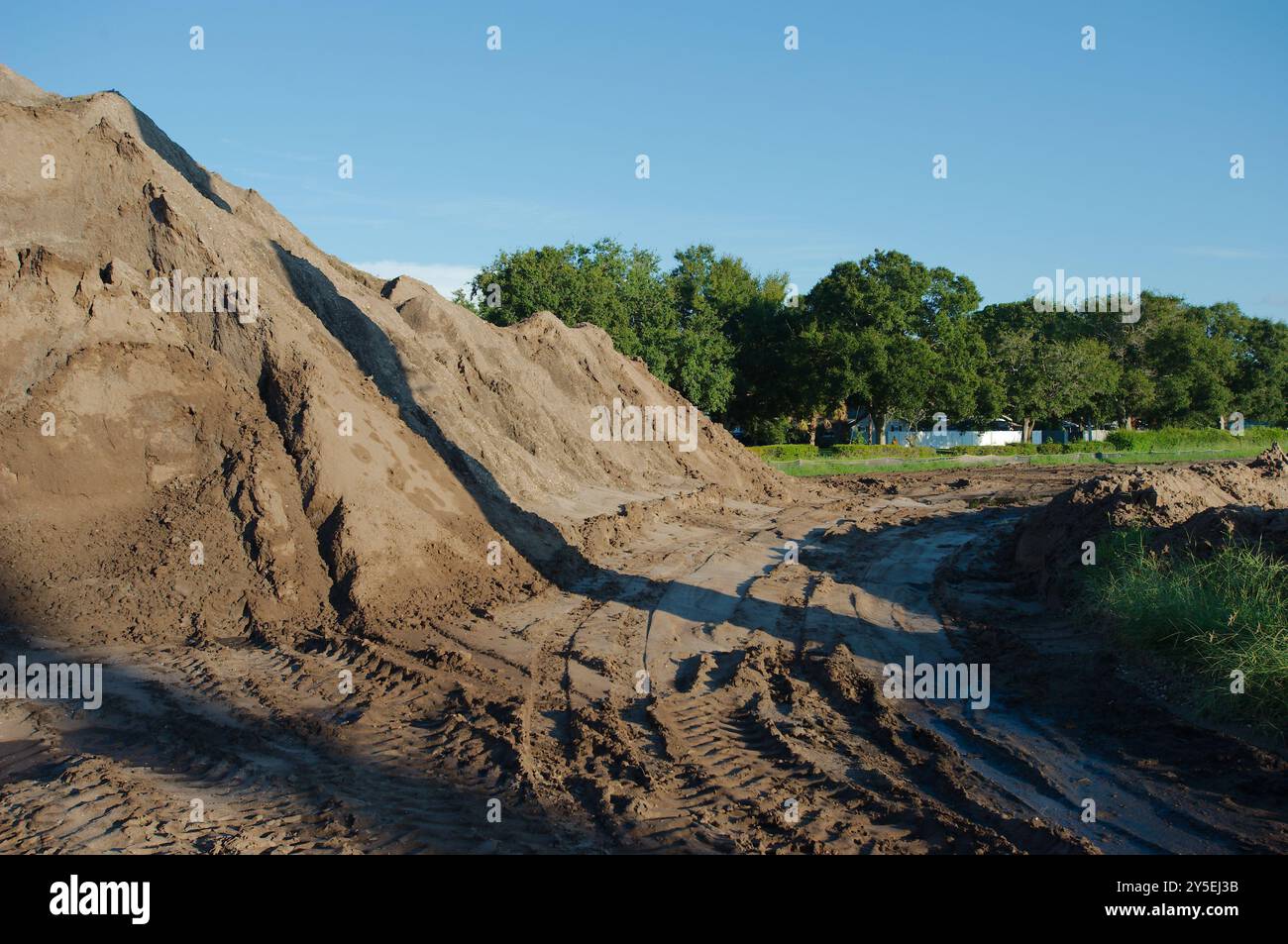 Wide view near dirt piles leading lines tire tracks near sunset large ...