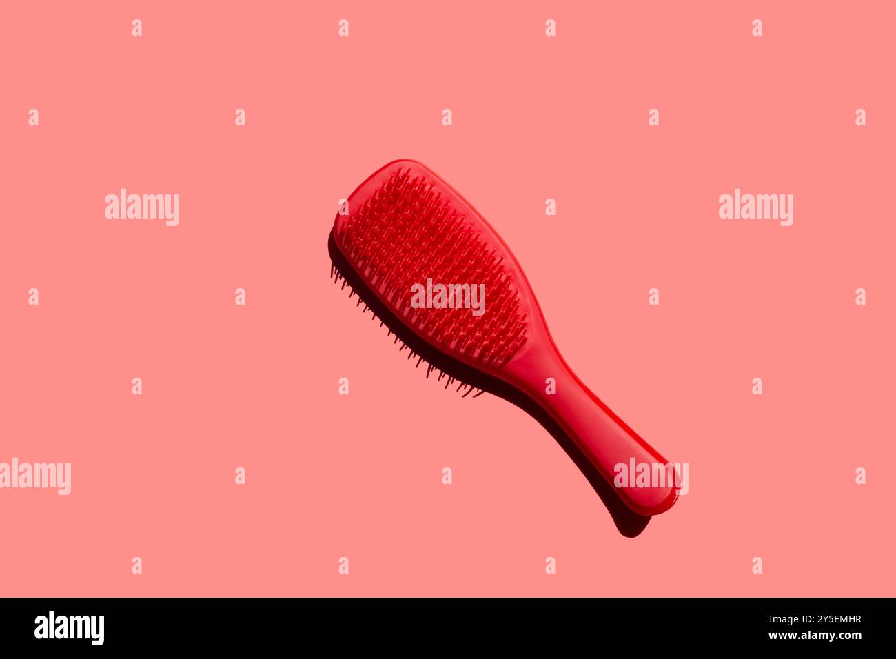 Bold Simplicity, plastic hairbrush takes center stage against a crimson ...