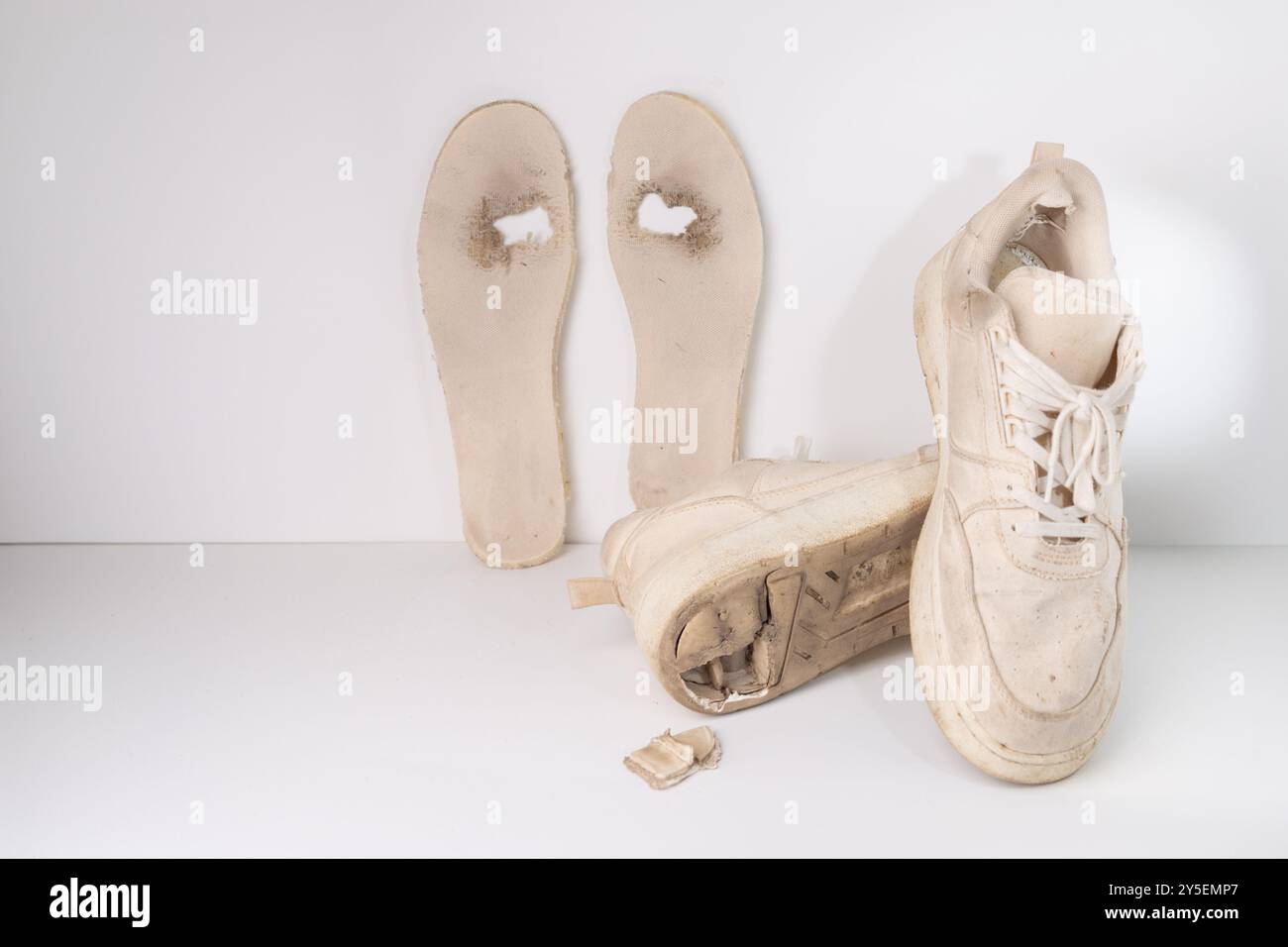 worn out white sneakers with a detached sole and removed insole ...