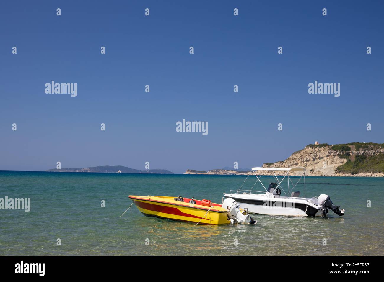 Two Motorboats Anchored in Clear Sea with Cliff View Stock Photo - Alamy