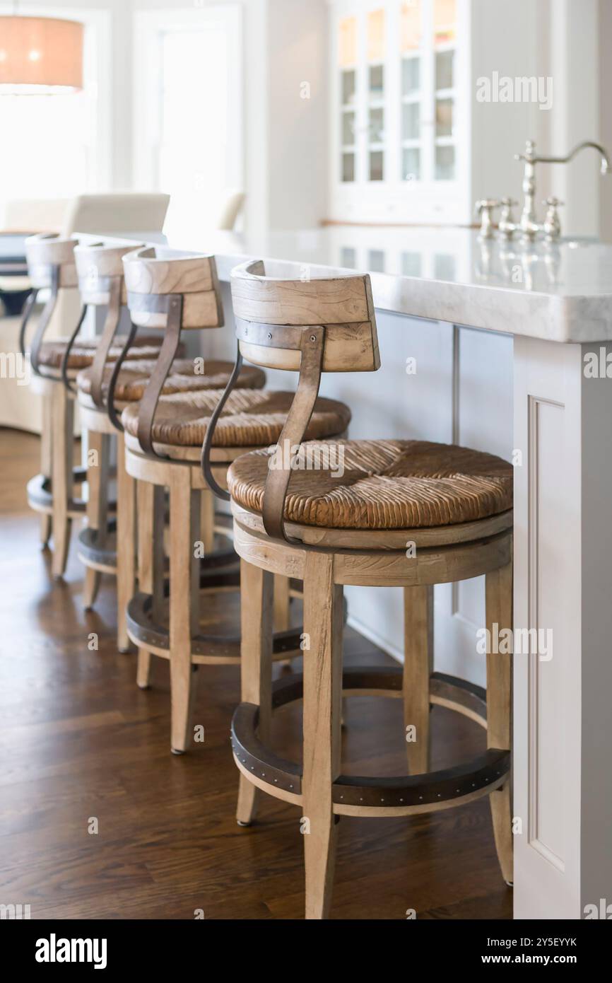 Kitchen island counter with rustic barstools Stock Photo - Alamy