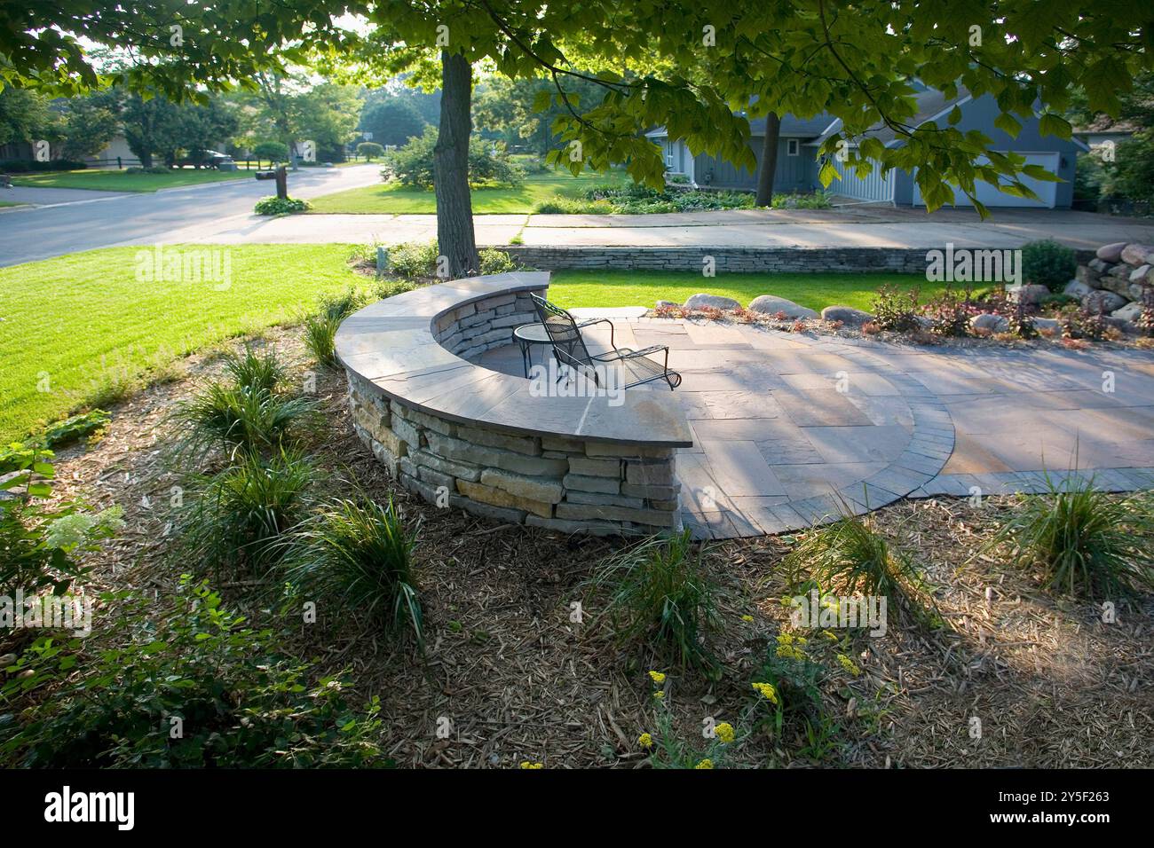 Seating area in front yard surrounded by stone wall Stock Photo - Alamy