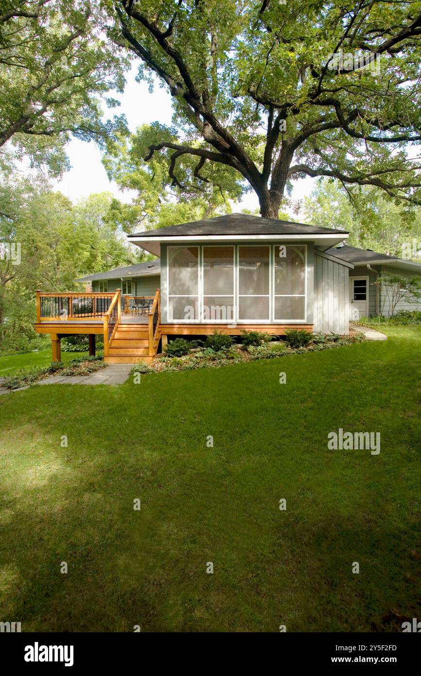 Screened porch and deck on gray split level house Stock Photo - Alamy