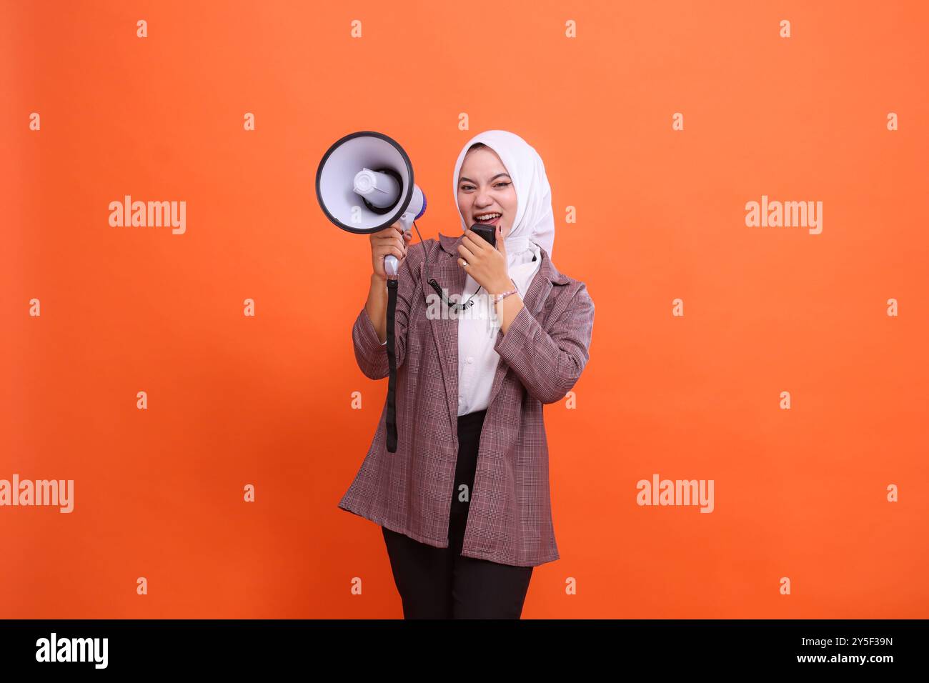 Angry young Asian woman in hijab facing right side to camera shouting ...