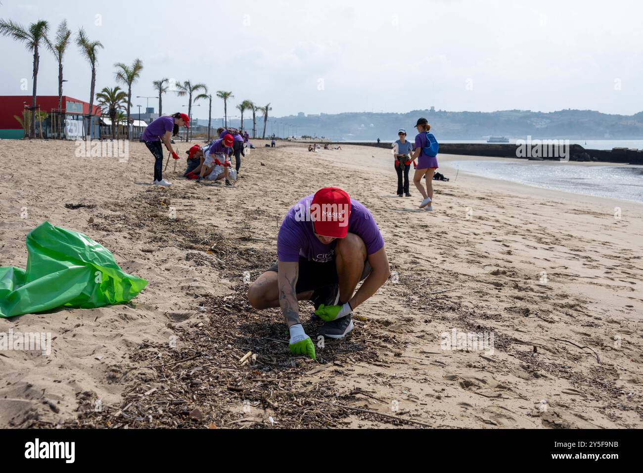 Volunteers seen collecting waste and garbage on the seashore during a ...