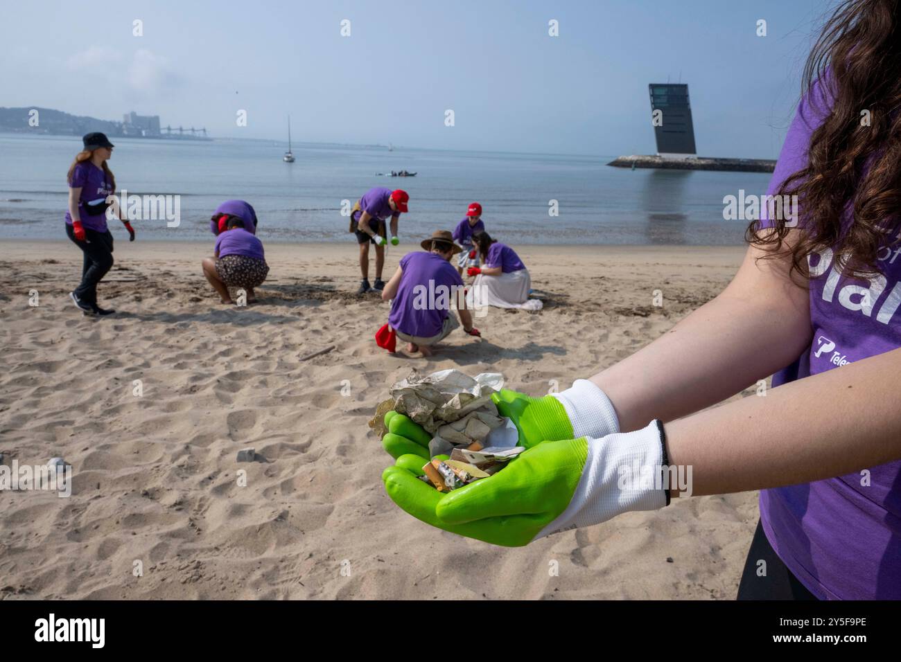 A volunteer shows the waste collected near the seashore during a beach ...