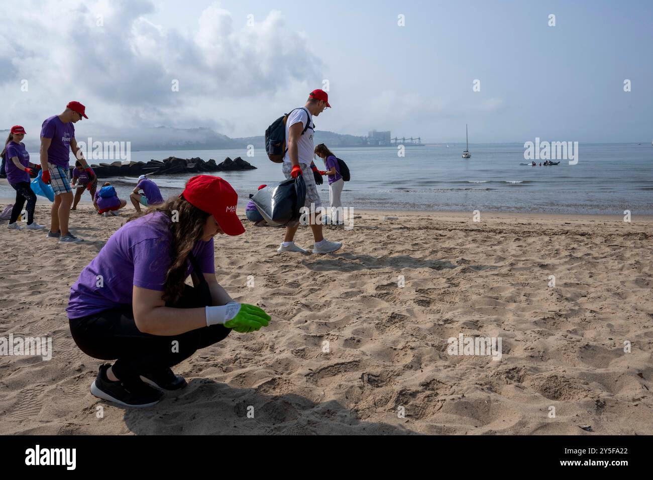Volunteers seen collecting waste and garbage on the seashore during a ...