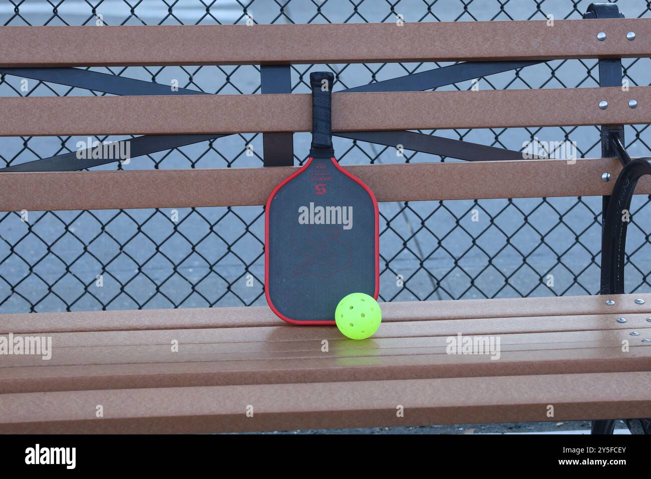 Pickleball paddle and Pickleball on bench near Pickleball court in New ...