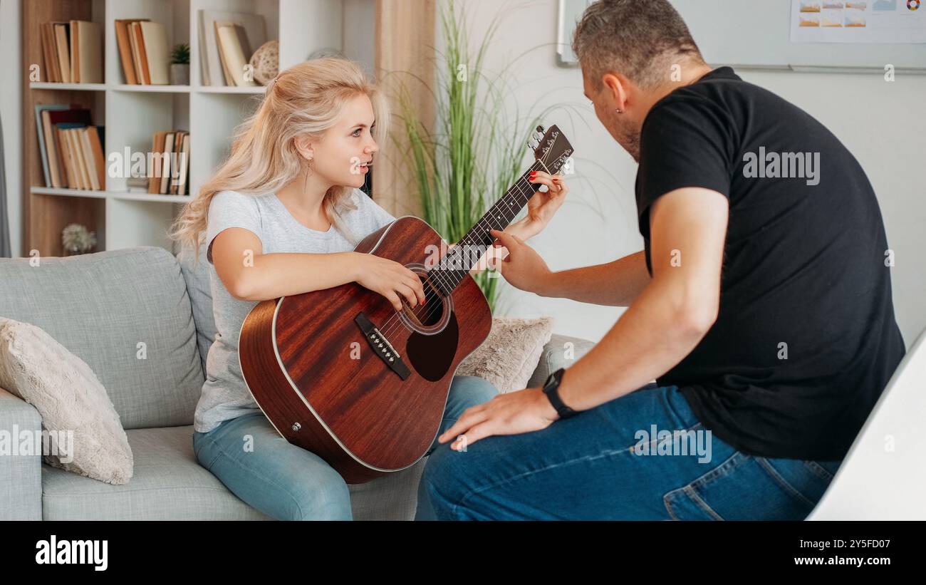 Guitar playing. Female student. Home courses. Male teacher showing base ...