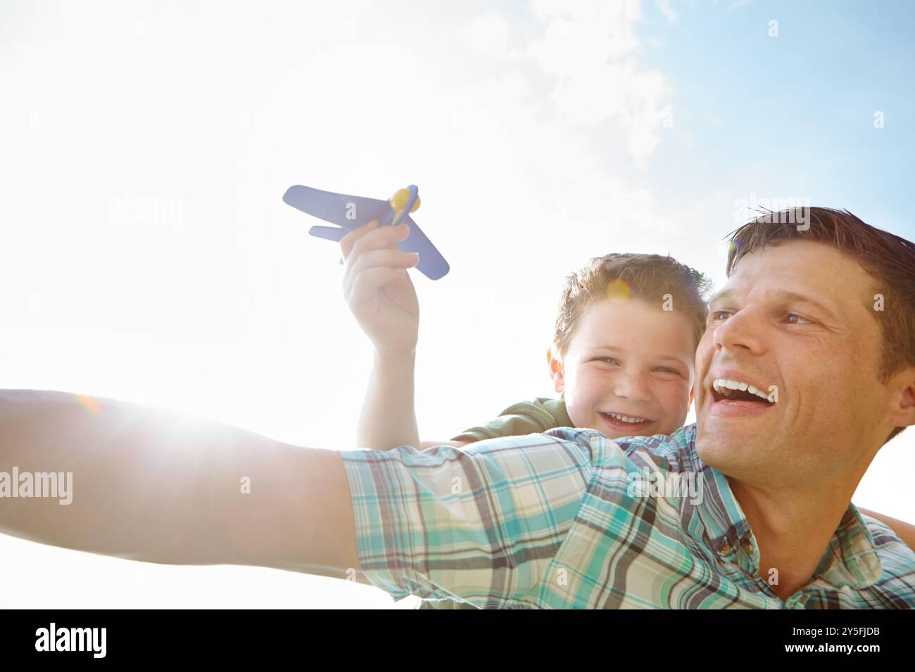 Laughing, piggyback or plane with father and son outdoor together for ...