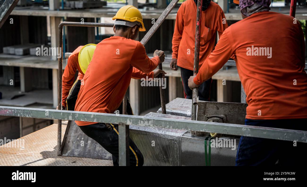 Workers at a building under construction take slabs from a crane Stock ...