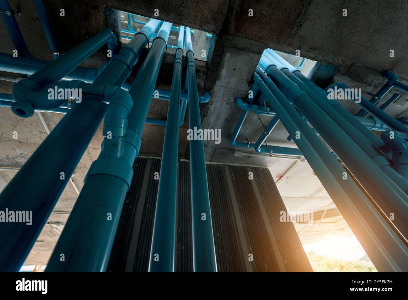 A large building currently under construction that has many blue pipes ...