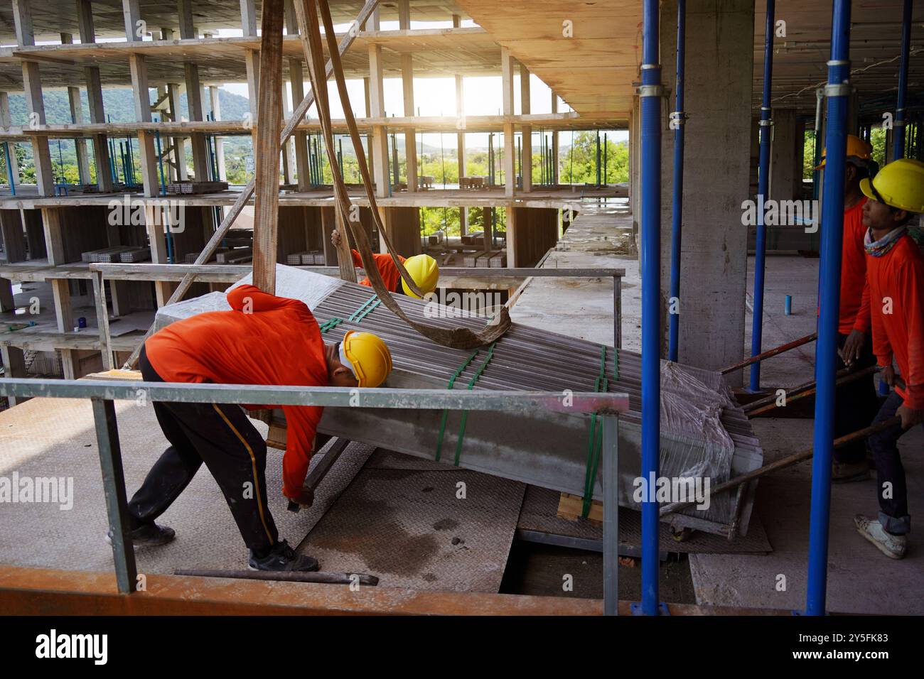 Workers at a building under construction take slabs from a crane Stock ...