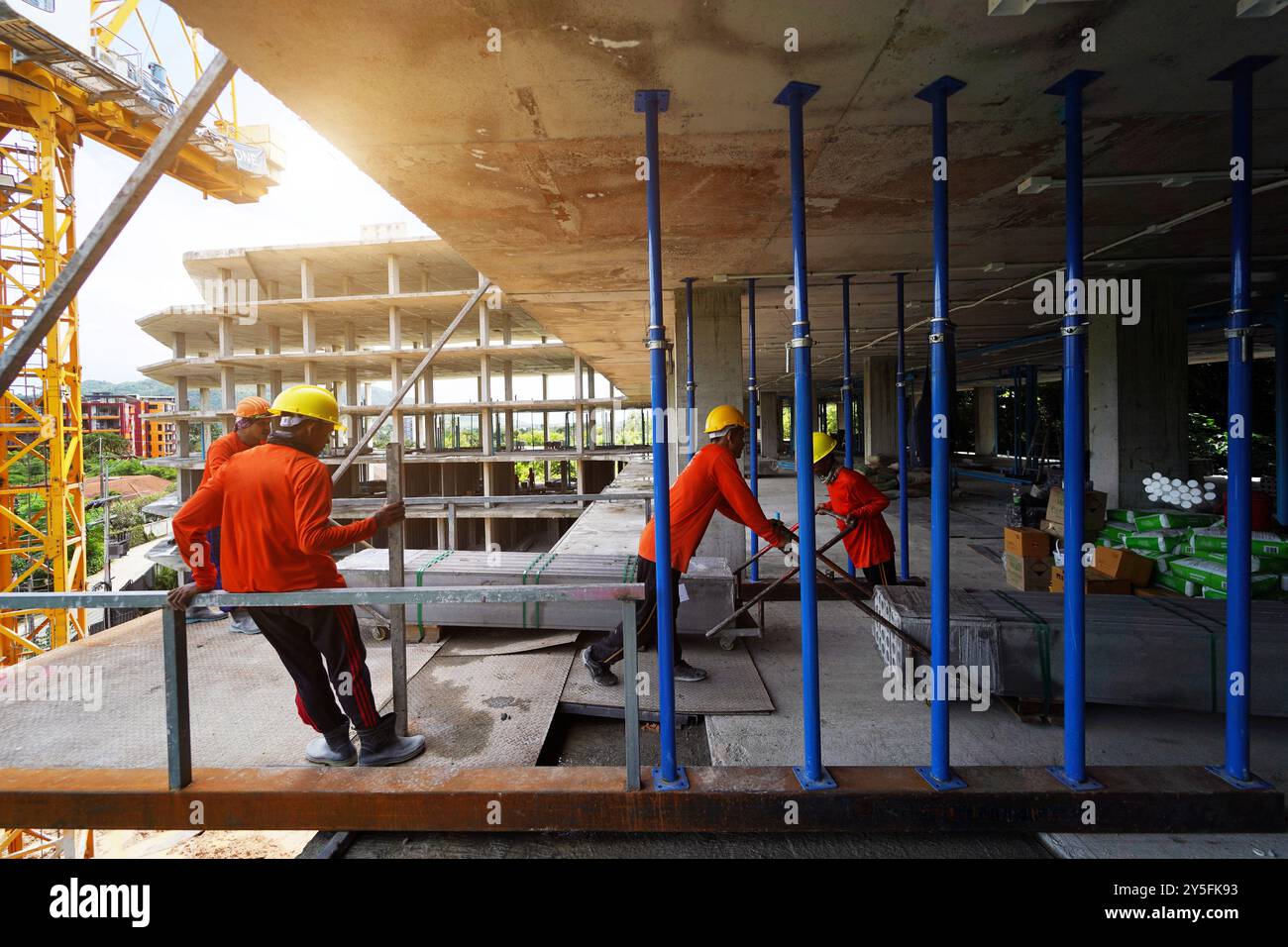Workers at a building under construction take slabs from a crane Stock ...