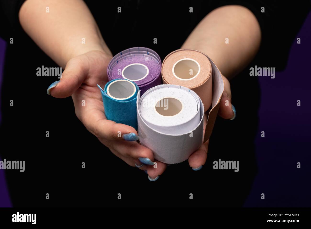 Kinesio tape in hands to support the muscles of the face and body ...