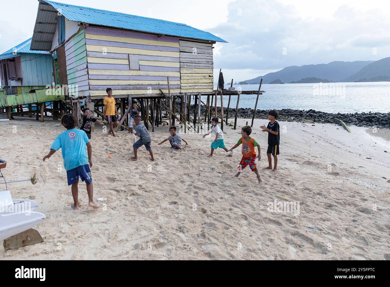Local kids playing on a beach near the sea in Bajau people village on ...