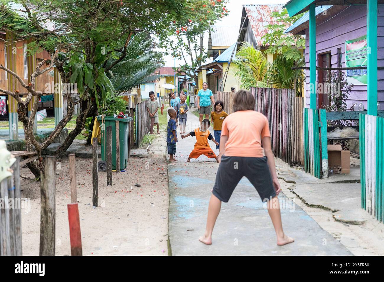 Teenager tourist playing, interacting with local kids in the street of ...