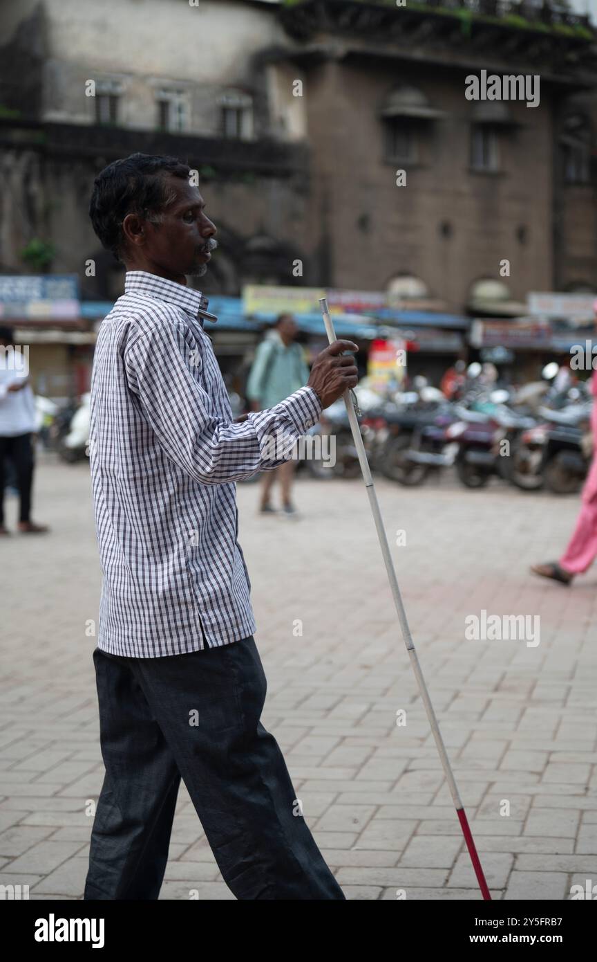 Kolhapur , India - 9 September 2024 A young blind Hindu man is walking ...