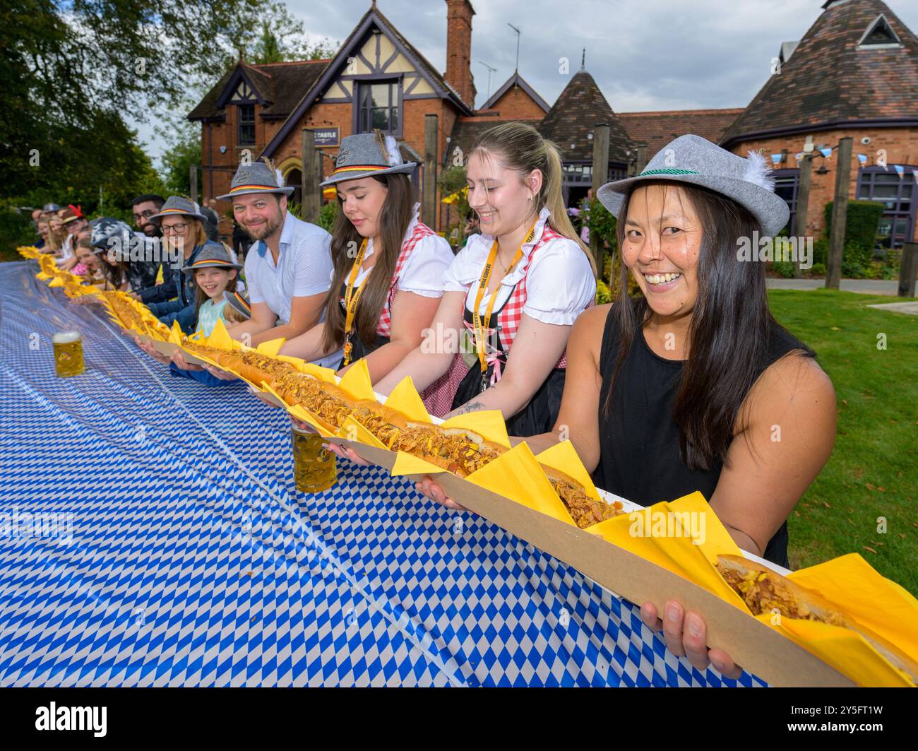 EDITORIAL USE ONLY A group of pub goers hold up a 12.12m long bratwurst ...