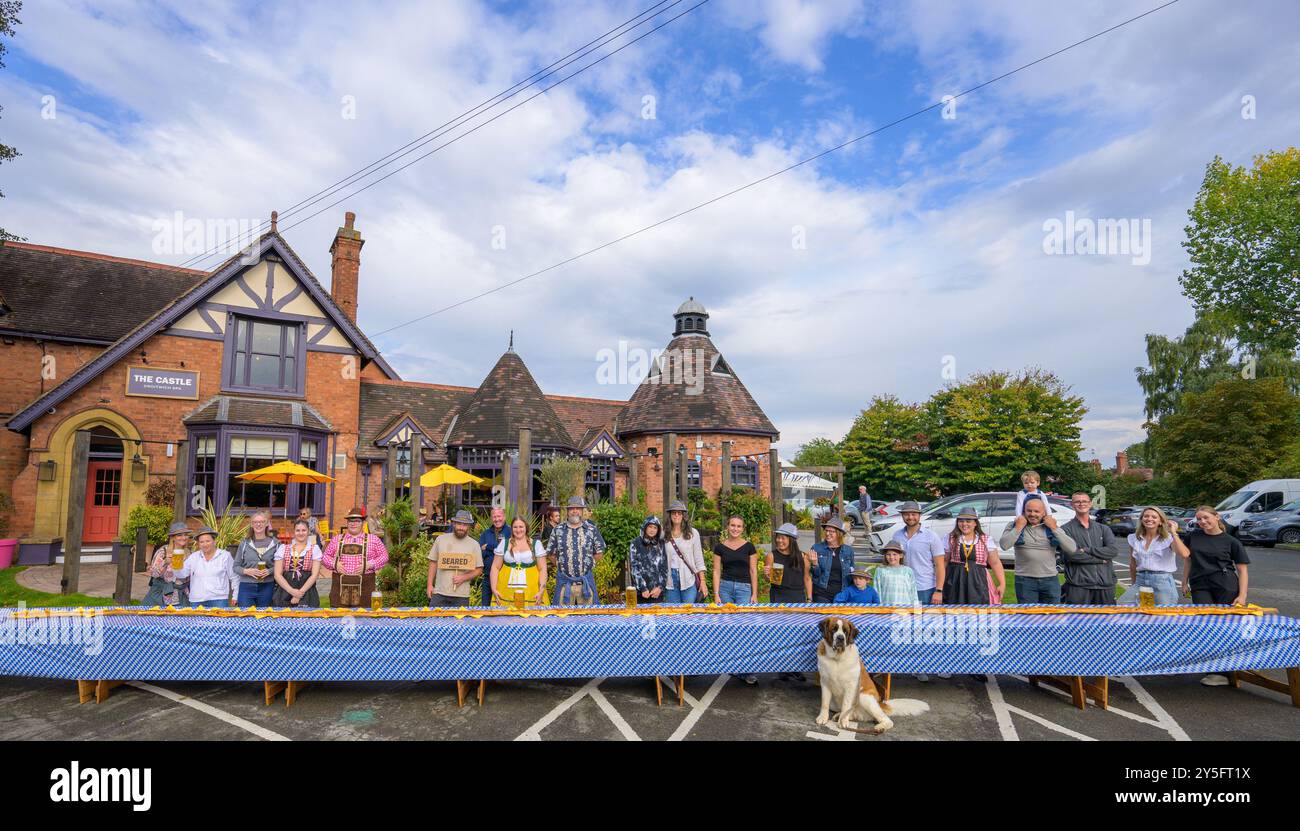 EDITORIAL USE ONLY A group of pub goers with a 12.12m long bratwurst ...