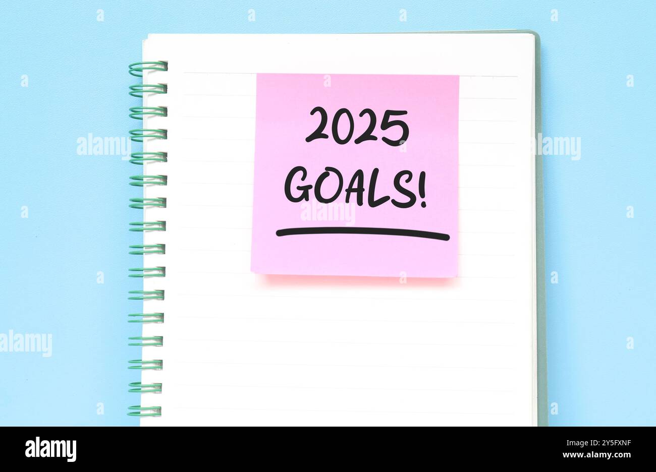 2025 Goals writing in notebook isolated on blue background. New year ...