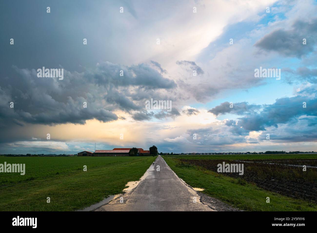 Road leading to massive storm cloud over a farm Stock Photo - Alamy