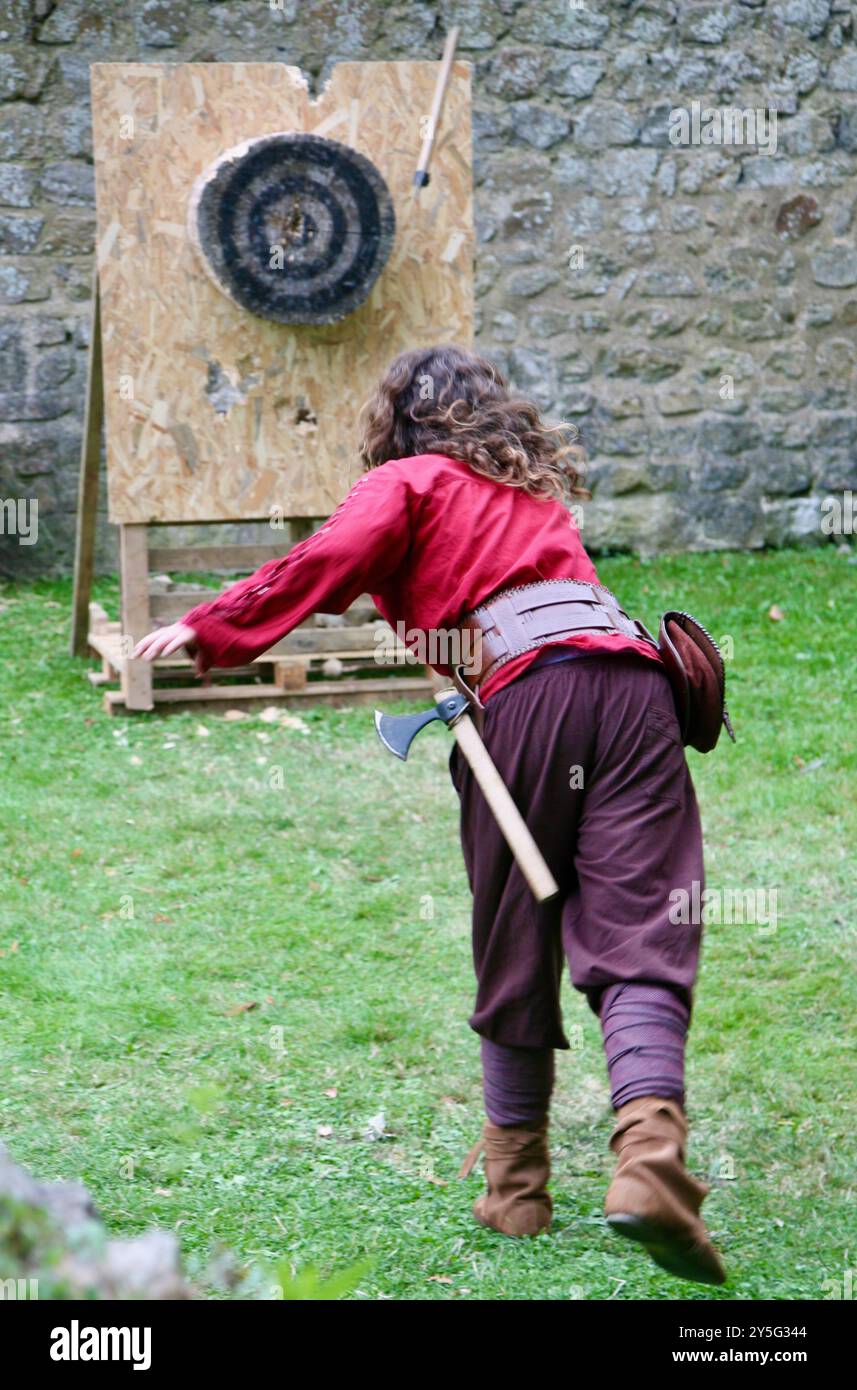 A man throwing an axe at the Medieval Craft Market, Domfront en Poiraie ...