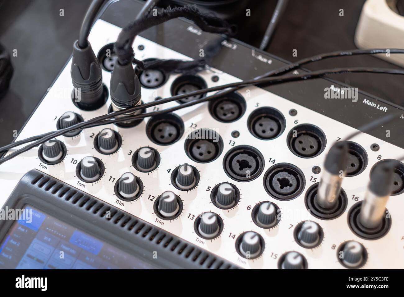 A close-up view of a professional audio mixer with multiple input ...