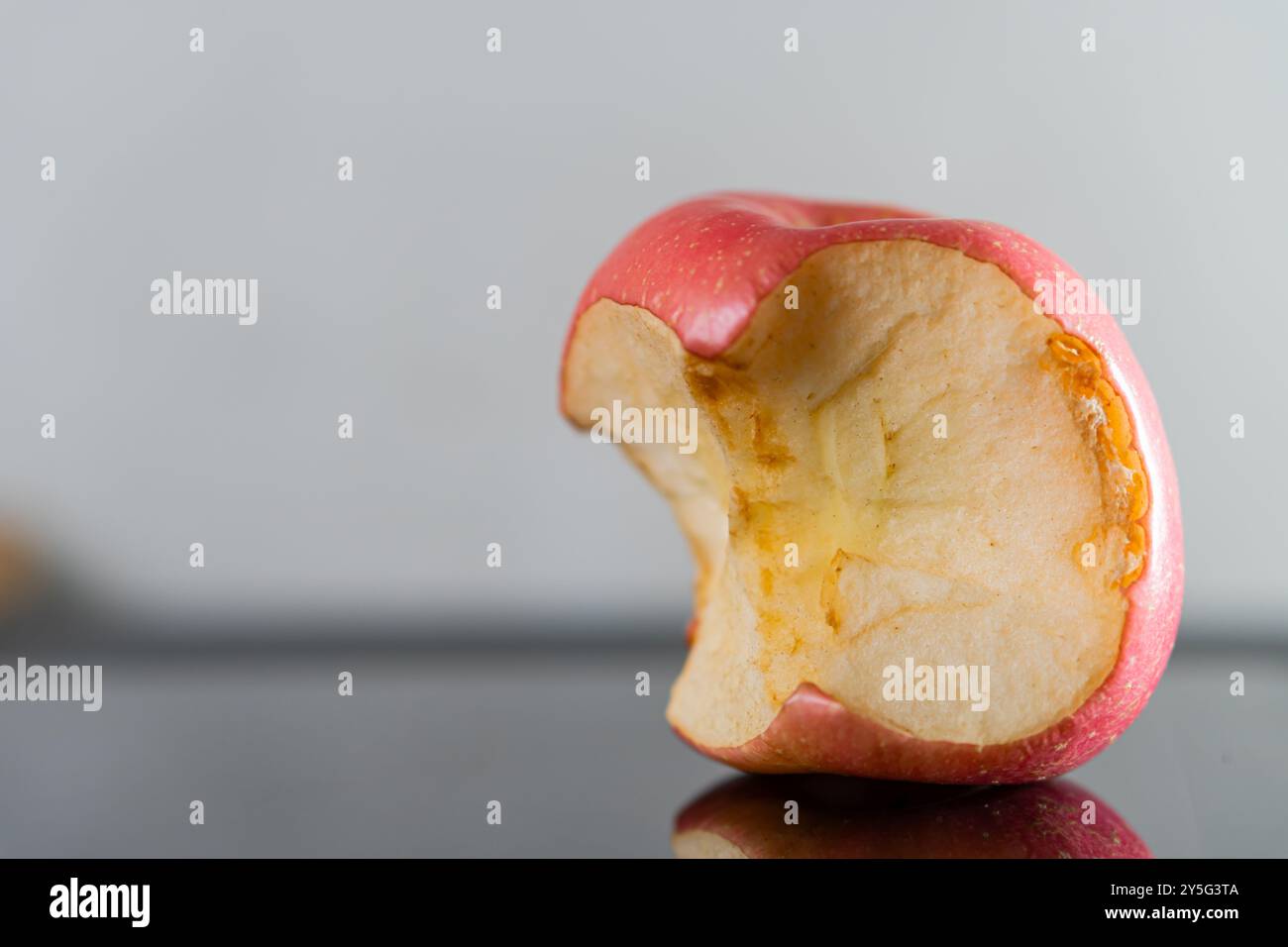 A close-up of a bitten red apple, showcasing its interior with a smooth ...