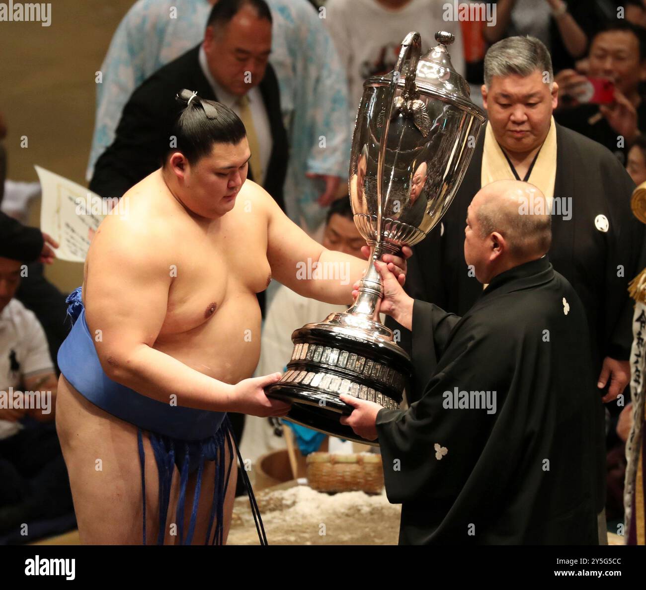 Sekiwake Onosato of Japan (L) receives a victory trophy on the final ...