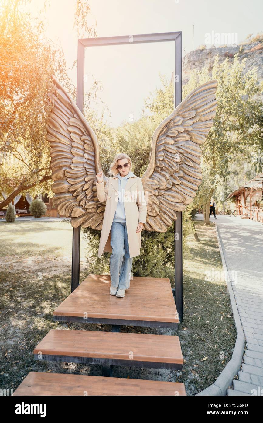 Woman Standing Under Large Angel Wings Sculpture Stock Photo - Alamy