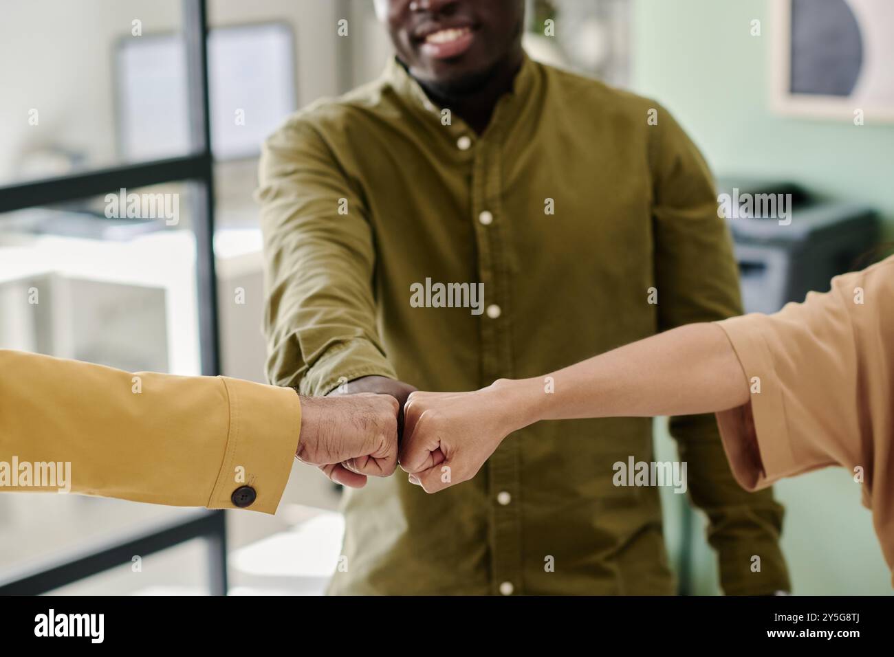 Group of colleagues greeting each other with handshakes in modern office environment, showcasing ...