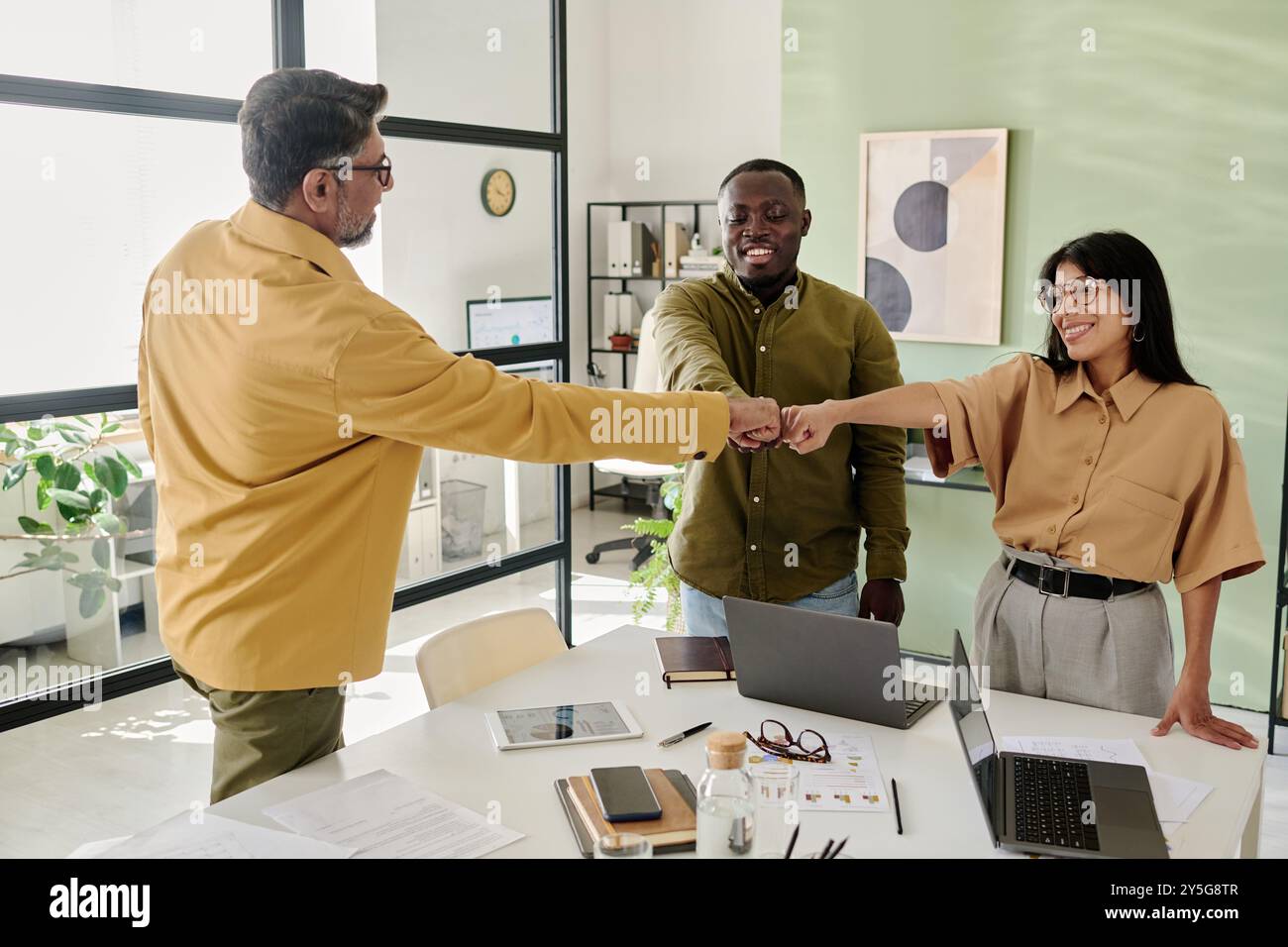 Smiling business team congratulating each other with handshake in ...