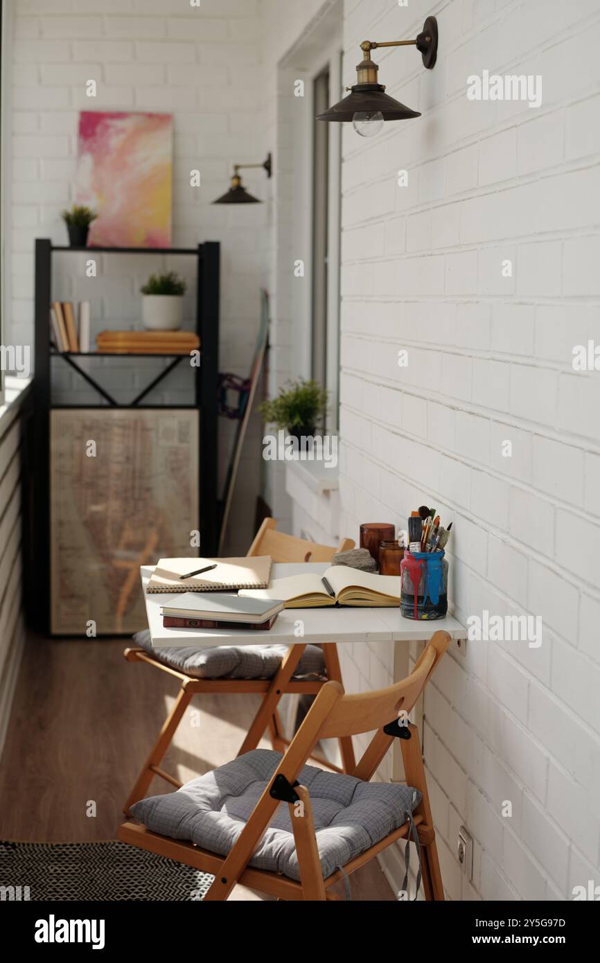 Comfortable workspace featuring books, wooden chairs, and writing ...