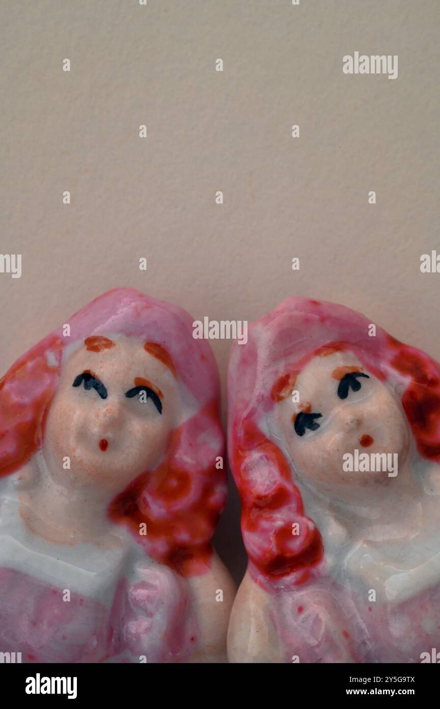 Heads of two almost identical china dolls of young Victorian girls with ...