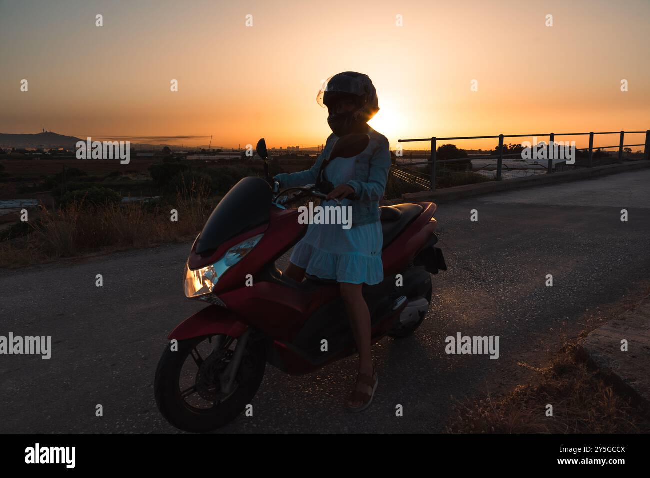 Woman with helmet on a motorcycle ready to start her journey at dawn ...