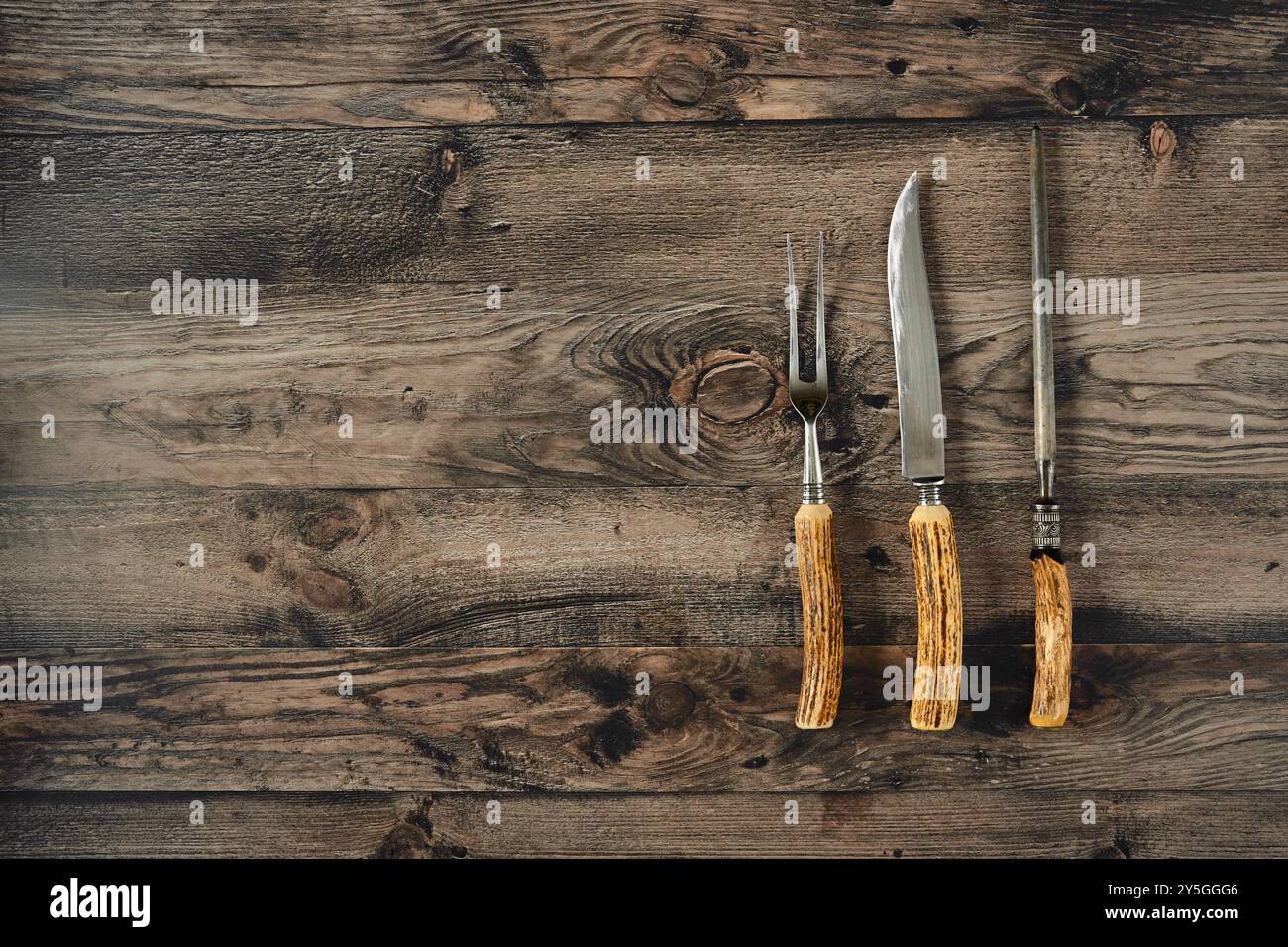Three essential barbecue tools on a rustic kitchen table made of dark ...