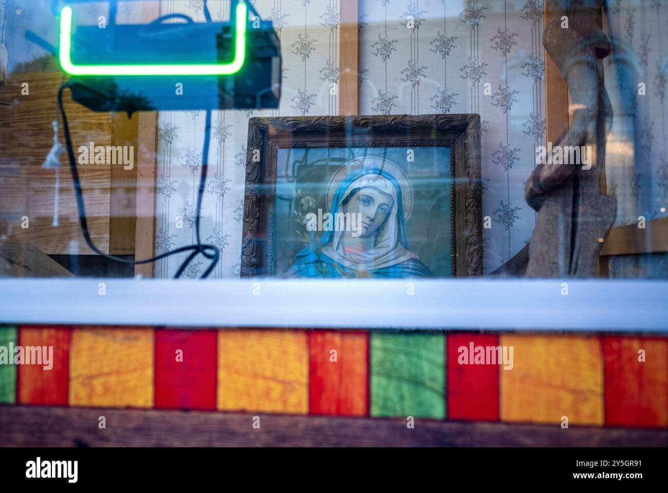 An old print of the Virgin Mary under a neon sign at a bar in downtown ...