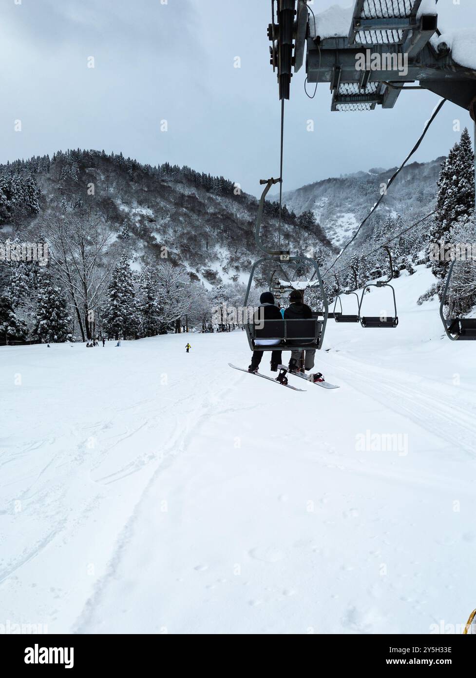 Snowboarders riding up ski lift hi-res stock photography and images - Alamy