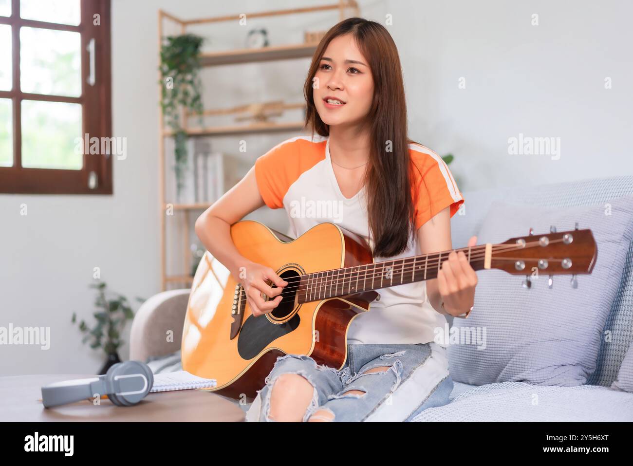 Guitar and singer concept, Young woman singing and playing music with ...