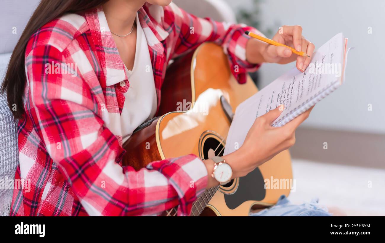 Guitar and singer concept, Young woman is composing song while playing ...